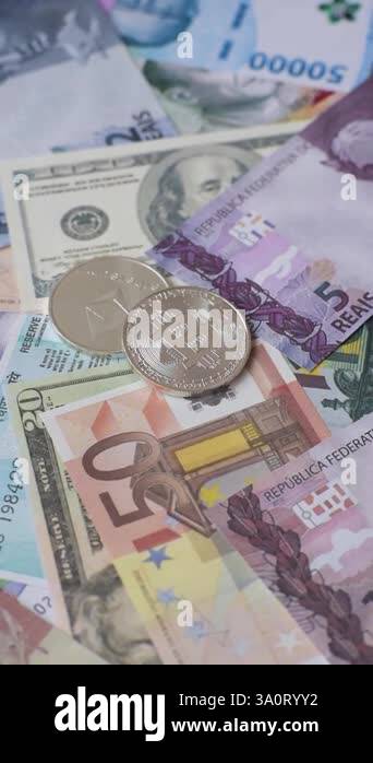 Round metal bitcoin on a background of paper banknotes of different ...