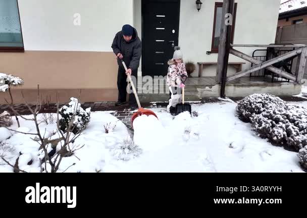 Happy dad and daughter clearing snow near house in winter outside Stock ...