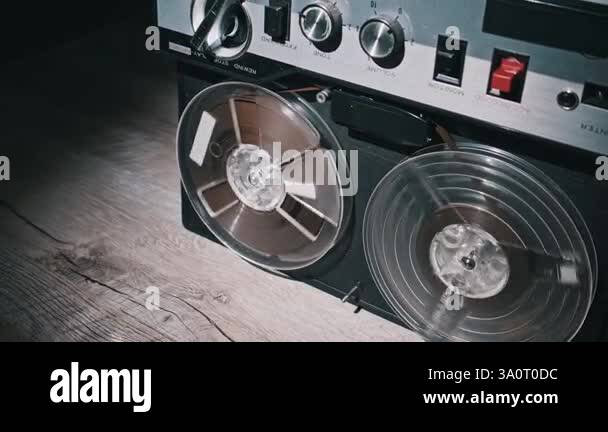 Close-up of a hand adjusting a control knob on a vintage reel-to-reel ...
