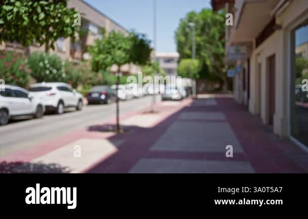 Blurred view of outdoor streetscape with defocused cars and trees along ...