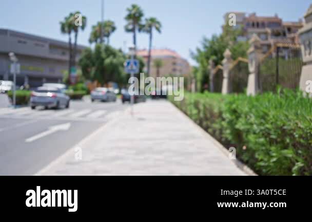 Defocused outdoor street scene with cars passing by and blurred ...