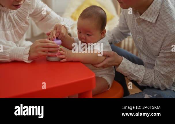 Family enjoys quality time with baby indoors, featuring a mother ...