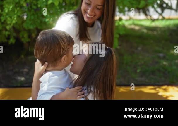 Woman embracing two children in an urban park setting, showcasing ...