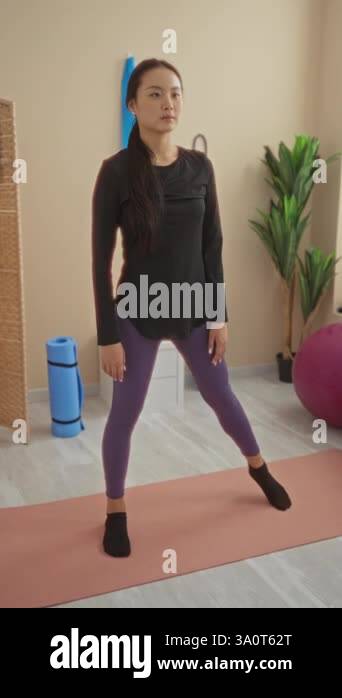 Chinese woman practicing stretching in an indoor gym, surrounded by ...