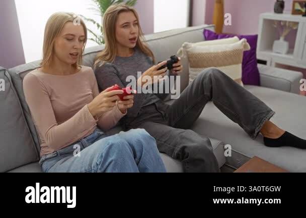 Women playing video game on couch in cozy living room, showcasing ...