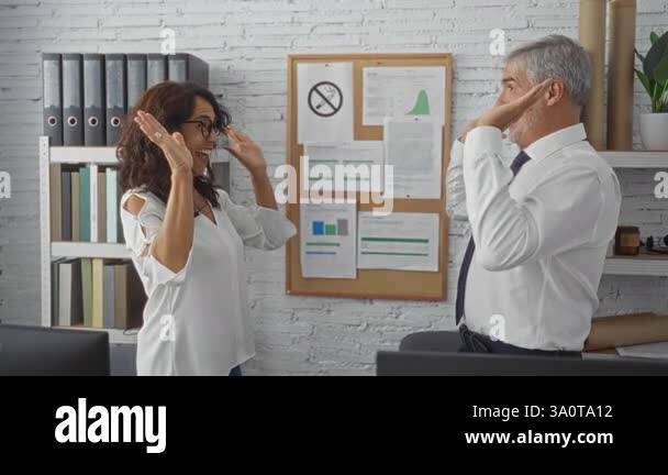 Man and woman happily embrace in a modern office setting, surrounded by ...