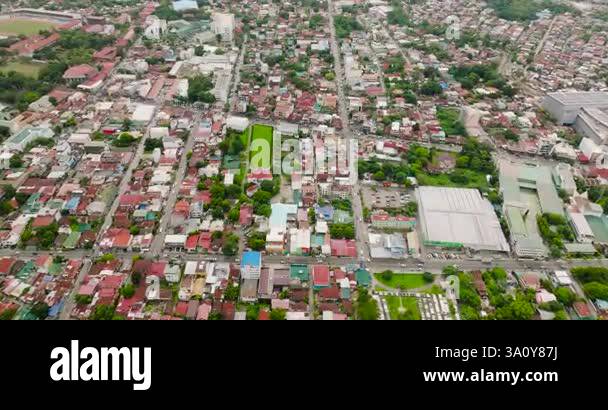 Flying over the buildings and streets with cars in Iloilo City. Panay ...