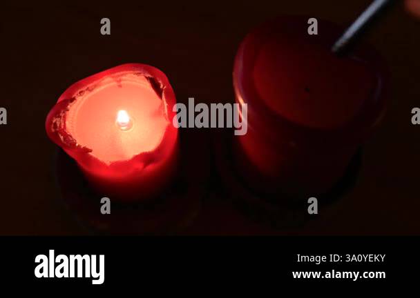 Igniting and then putting out candles. Igniting two red candles with a ...