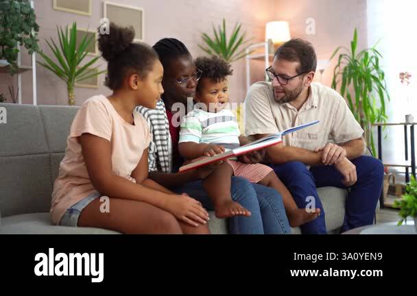 A joyful family enjoys a special moment as they gather around to read a ...