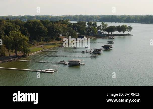 The aerial capture of lakeside scene with several docks extending into ...