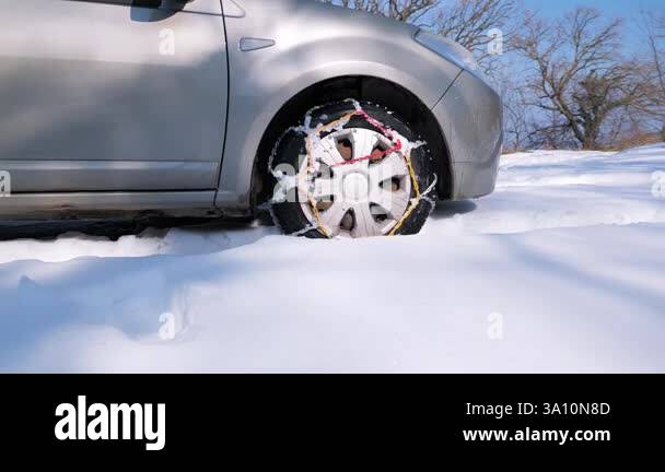 Close-up of a car wheel with snow chains installed for winter driving ...