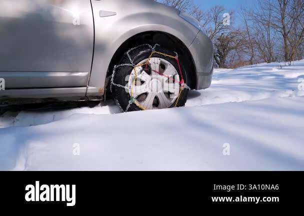 Close-up of a car wheel with snow chains installed for winter driving ...
