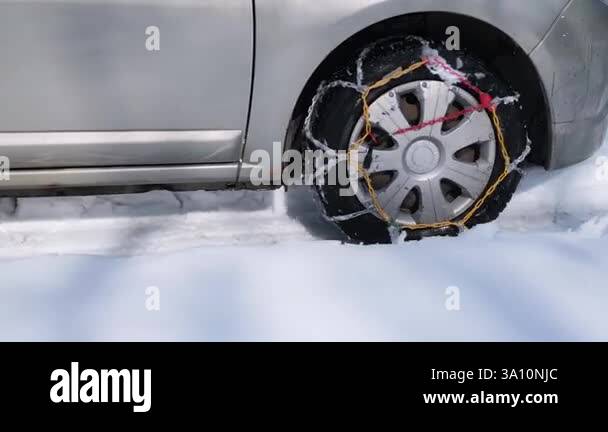 Close-up of a car wheel with snow chains installed for winter driving ...