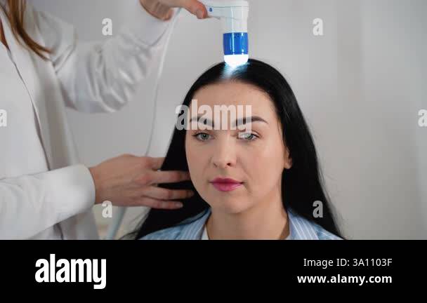 A woman visits a trichologist for a scalp examination using a digital ...