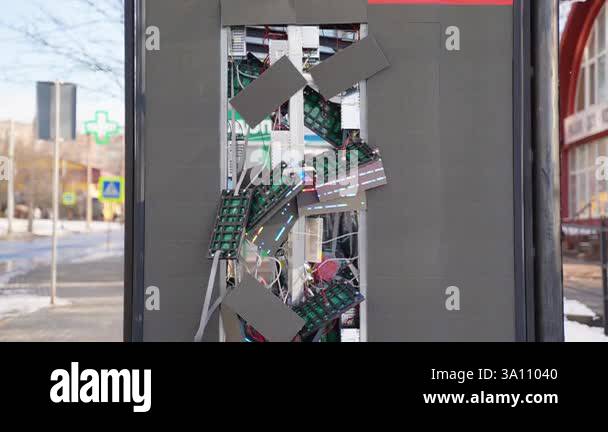 A broken digital billboard with shattered LED panels, exposed circuits ...