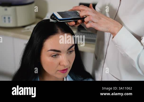 A woman visits a trichologist for a scalp examination using a ...