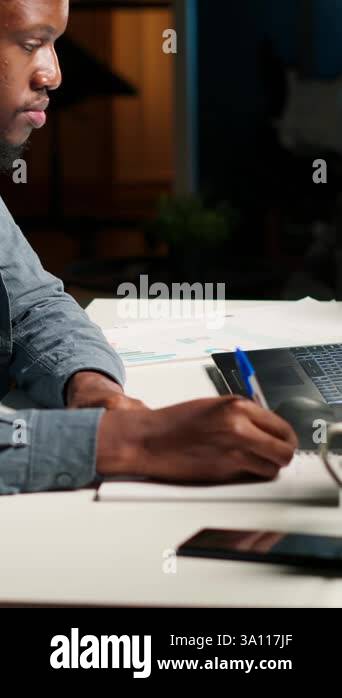 Vertical Video Self employed Black man multitasking at home taking ...