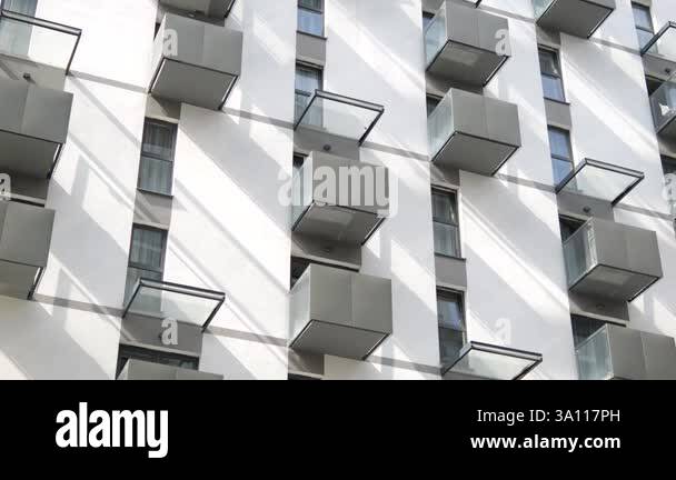 Sunlight creates strong shadows on the balconies of a modern apartment ...
