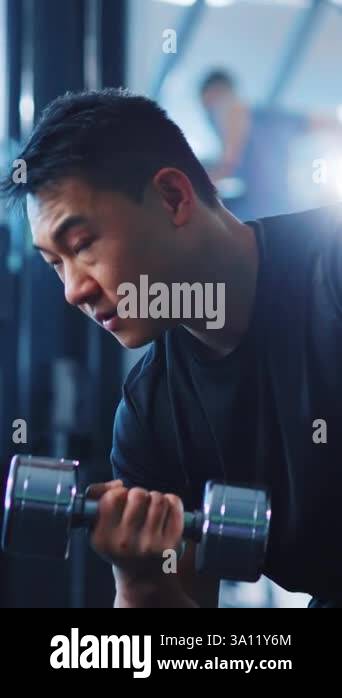 Muscular asian bodybuilder man training with heavy dumbbells working ...