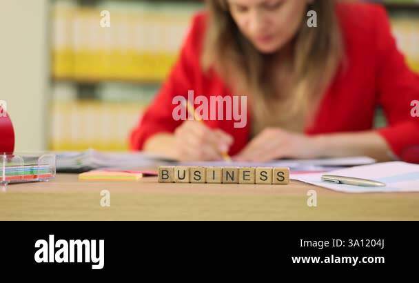 Word Business on blocks against woman filling papers in corporate ...