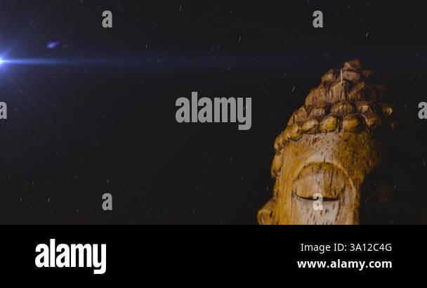 Statue of Buddha in subtle light, partially visible against dark ...