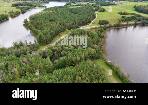 Aerial view of a lush green forest surrounded by two large lakes, with ...