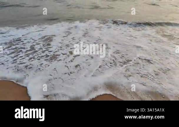 the sea wave coming by the banks with and mixing with the sand. in the ...