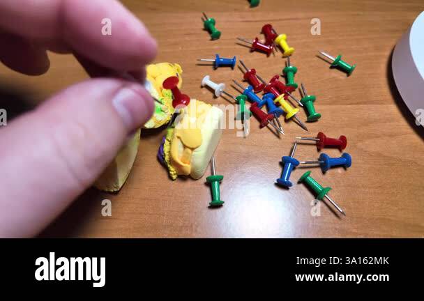 Push pins on the table slow motion video. Colorful push pins falling ...