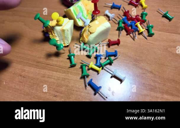 Push pins on the table slow motion video. Colorful push pins falling ...