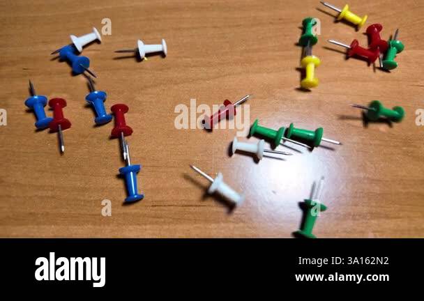 Push pins on the table slow motion video. Colorful push pins falling ...