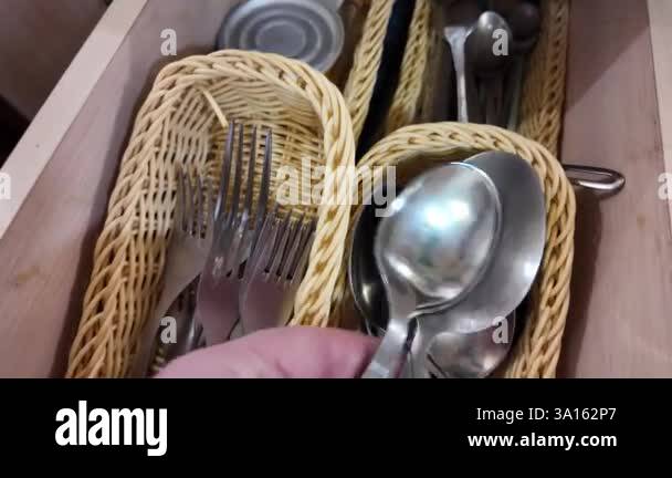 spoons and forks in a drawer in the kitchen. Opening the drawer with ...