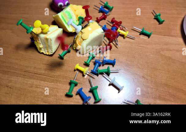 Push pins on the table slow motion video. Colorful push pins falling ...