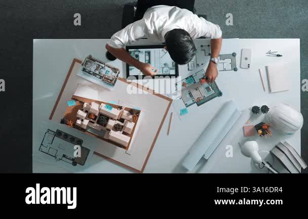 Top view of architect engineer looking house model and blueprint while ...