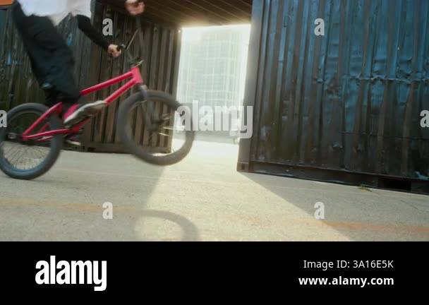 Young BMX rider in helmet and sportswear jumping on bike and rotating ...