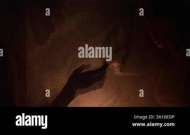 Low angle shot of two young people reaching out their hands to each ...