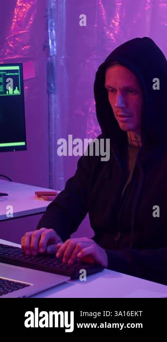 Vertical portrait of confident Caucasian male hacker using computers ...