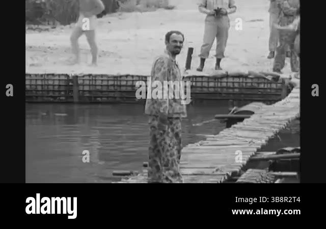 HAWAII - 1945 - Moss Hart crosses footbridge and enters raft with USO ...