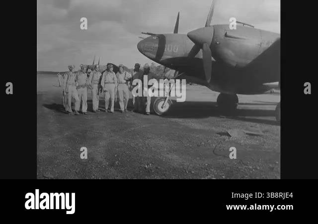 USA - 1944 - A group of pilots walks across the field, engaged in a ...
