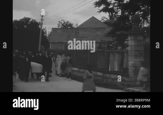 BAHAMAS - 1920 - A funeral procession on foot enters the church yard ...