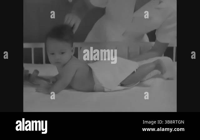 HONOLULU - 1954 - A WMSC nurse combs a baby's hair in a crib in a ...