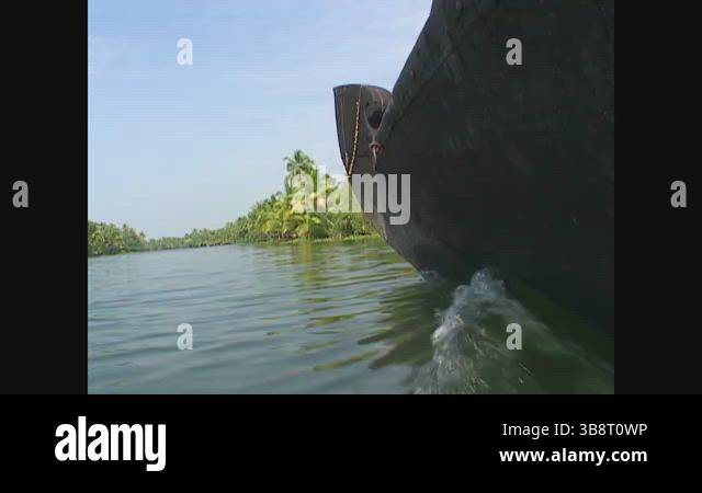 INDIA - 1999 - Close-up of a canoe cutting through the water past a ...