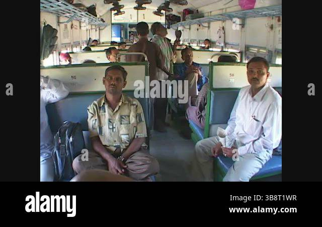 INDIA - 1999 - People pass through a train's corridor in India, eating ...