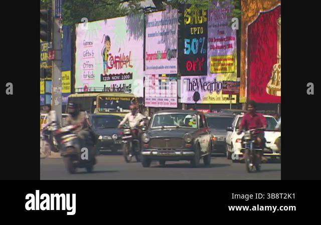 INDIA - 1999 - Zoom out from workers putting up a Bollywood billboard ...