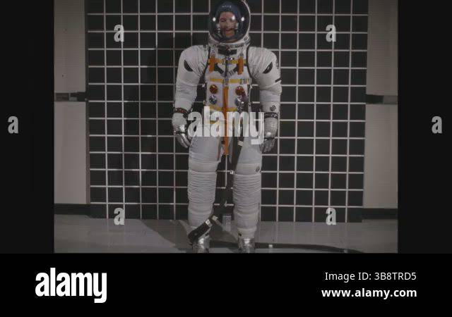 USA - 1965 - An astronaut in a liquid cooling space suit bends over for ...