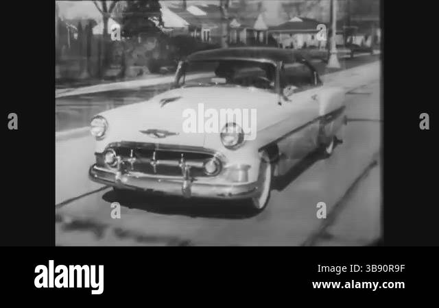 UNITED STATES - 1955 - A man drives a 1953 Chevrolet Bel Air coupe with ...
