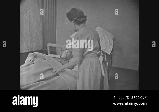 USA - 1950s - A nurse demonstrates how to help a patient sit up in bed ...