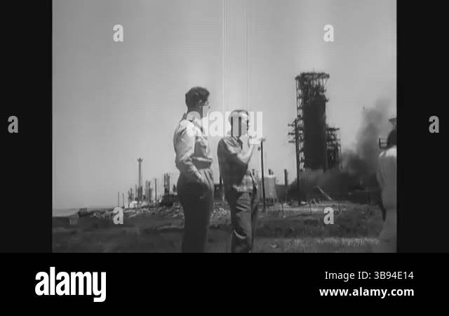 TEXAS CITY - 1947 - Onlookers watch a flaming oil tank from a refinery ...