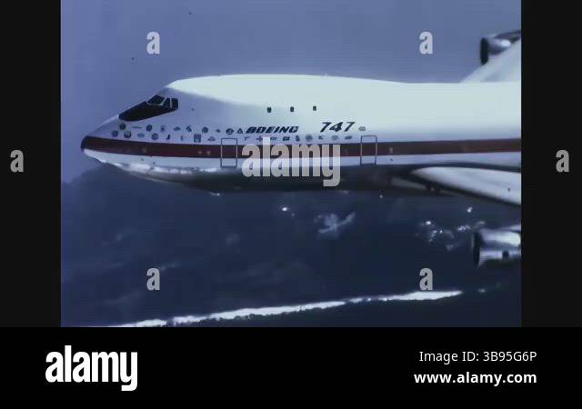 UNITED STATES - 1969 - A Boeing 747-100 flying over a coast and a group ...