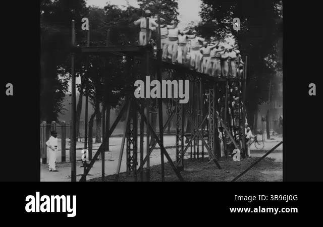 BRITAIN - 1897 - Men in a gymnastics school slide down poles and jump ...
