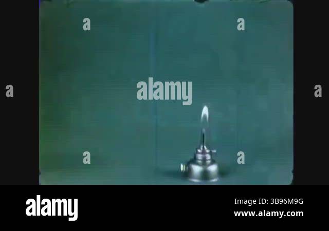 UNITED STATES - 1939 - A man burns a wooden splint from a lamp. He puts ...